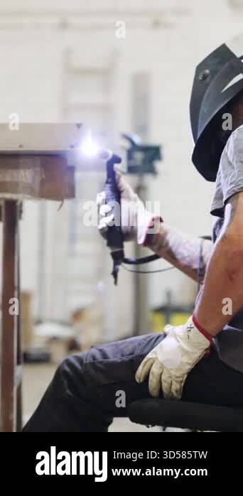 Skilled professional welder using a torch for metalworking in a factory ...