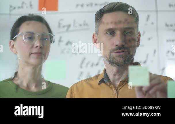 Two business colleagues are actively engaged in a brainstorming session ...