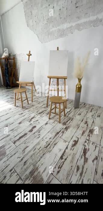 This bright art studio features a large table, a comfy chair, and ...