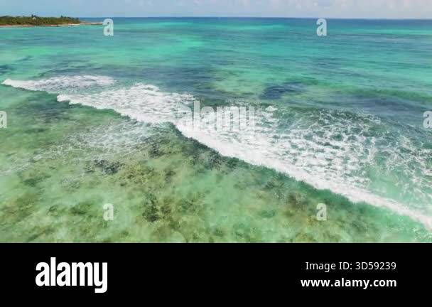 Waves breaking on coral reef in shallow turquoise tropical Caribbean ...