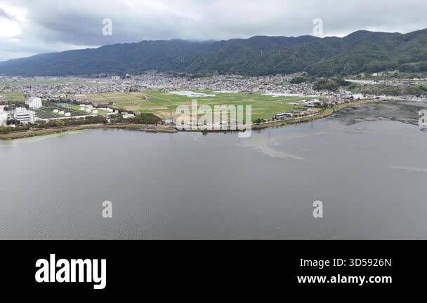 Aerial view of green fields near calm water body Stock Video Footage ...