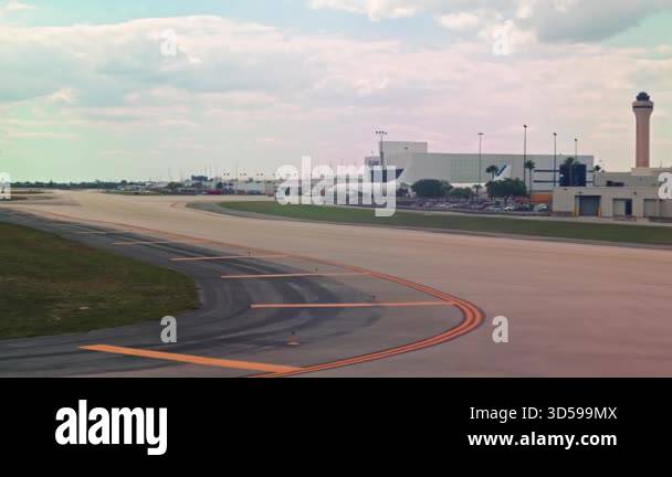 Airplane taxiing at Miami International Airport with curved runway ...