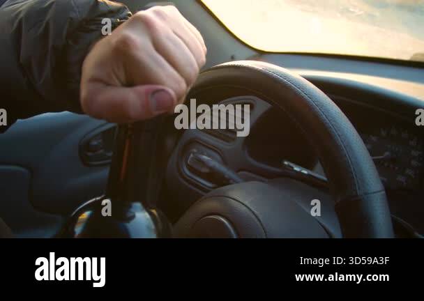 The driver drinks strong alcohol while driving. Drunk driving. The ...