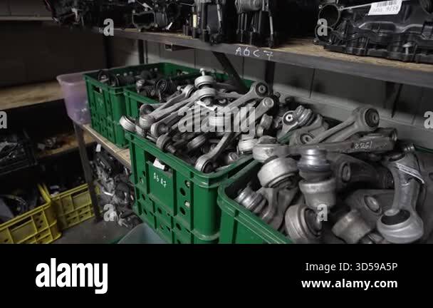 Metal automotive suspension arms in green crates, Organized storage of ...