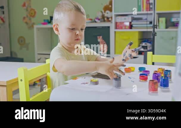 Cute toddler boy having fun painting with his fingers on a piece of ...