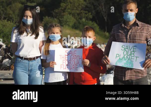 Young couple with kids in medical protective masks standing against ...