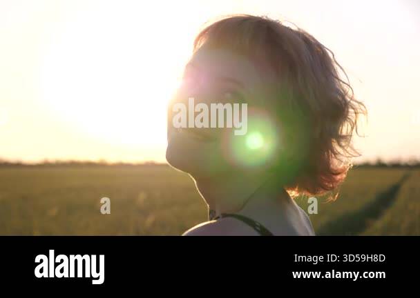 Happy punk girl with pink hair looks into camera standing on barley ...