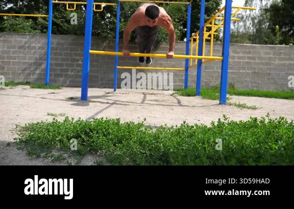Sportsman engages in a continuous workout sequence on parallel bars ...