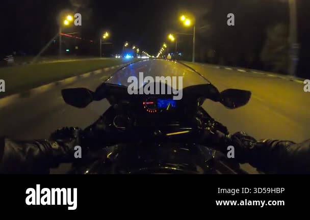 Biker navigating through a vibrant night cityscape on a motorcycle ...
