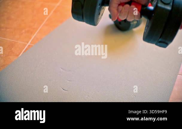 Slow motion of a person placing a pair of adjustable dumbbells on the ...