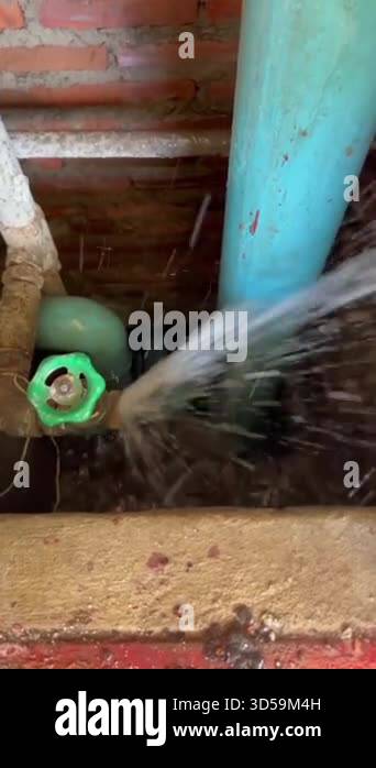 Plumber repairing a broken PVC water pipe with strong water leakage ...