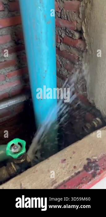 Plumber repairing a broken PVC water pipe with strong water leakage ...