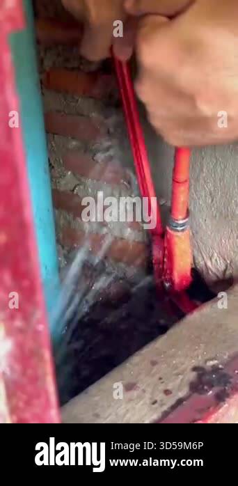 Plumber repairing a broken PVC water pipe with strong water leakage, maintenance and plumbing ...