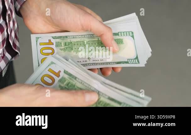 This closeup shot shows hands counting stacks of cash, highlighting the ...