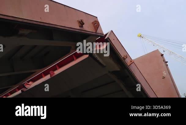Opening metal gate of ship hull containing cargo containers in marine ...