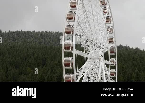 A large white Ferris wheel stands gracefully against the backdrop of a ...