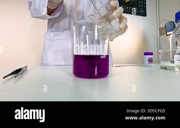 A scientist demonstrates a chemical reaction causing a color change in ...