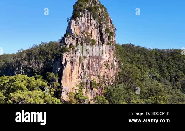 Aerial footage capturing the majestic Nimbin Rocks against a clear blue ...