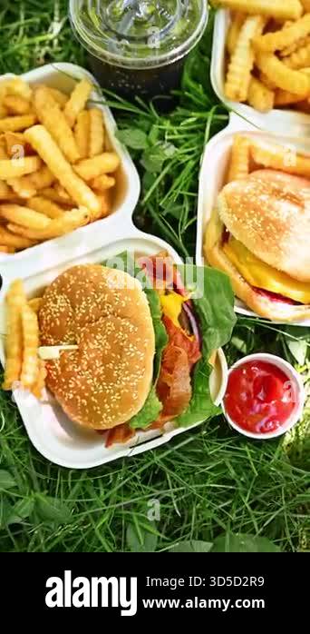 Summer picnic lunch with burgers fries and cola. Outdoor fast food ...