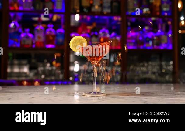 Amber cocktail with lemon slice and ice in coupe glass. Amber cocktail ...