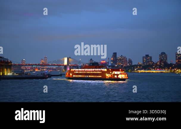 New York, USA, 1 August 2025: Night ferry near illuminated bridge in ...