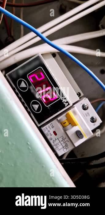 Vertical, close-up of a digital voltage relay with a glowing red ...