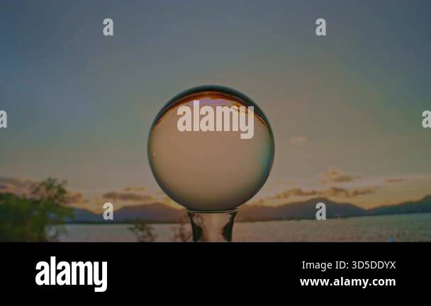 Glass sphere reflecting sunset over mountains Stock Video Footage - Alamy