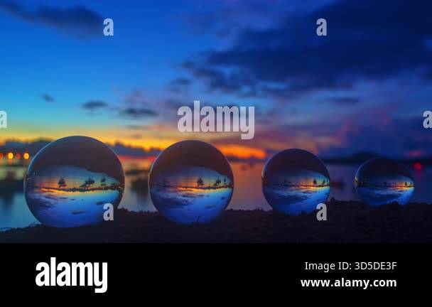 Three glass orbs reflecting sunset colors Stock Video Footage - Alamy