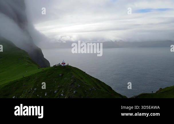 Aerial view of Kallur lighthouse on green hills of Kalsoy island, Faroe ...