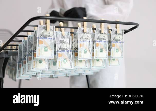 Money laundering. Woman hanging banknote on drying rack indoors ...