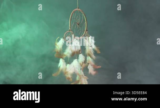 Beautiful dream catcher and smoke flowing in color light on dark ...