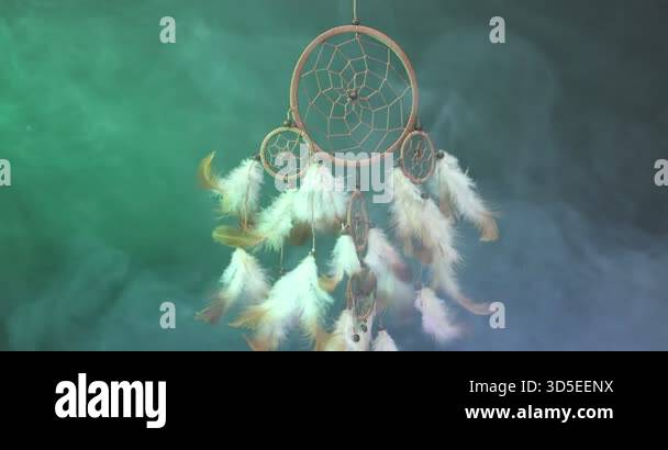 Beautiful dream catcher and smoke flowing in color light on dark ...