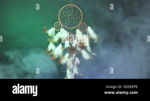 Beautiful dream catcher and smoke flowing in color light on dark ...