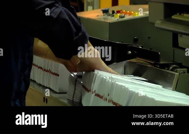 Postal Worker Loading Letters into Automatic Mail Sorting Machine at ...