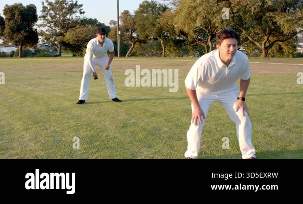 Bowling cricket ball, male teammates in uniforms practicing catch and ...