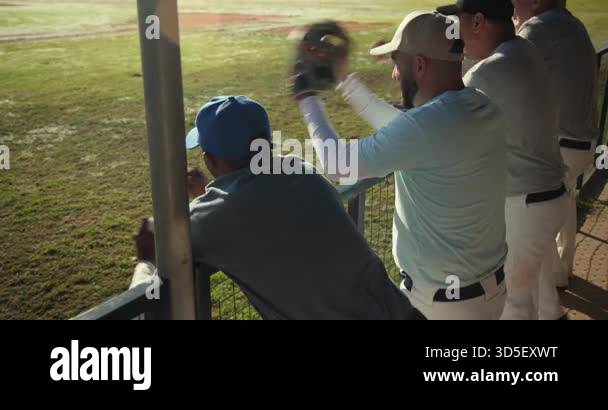 Catching incoming baseball by diverse male teammates leaning over ...