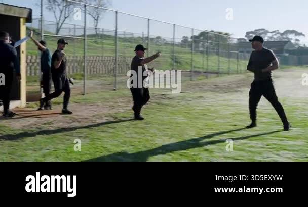 Gesturing male baseball team following senior coach gloving high-fiving ...
