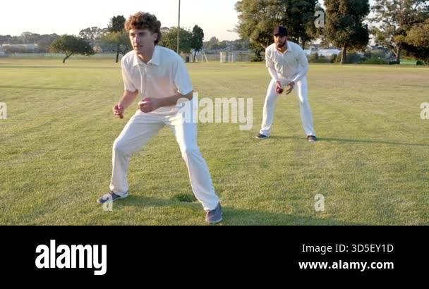 Receiving underhand red ball toss male cricket teammates catching ...