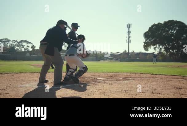 Reacting to wild pitch, male players chasing loose ball and covering ...
