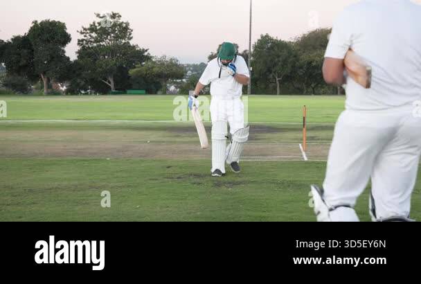 Responding to glove tap male cricket teammates running crease to crease ...
