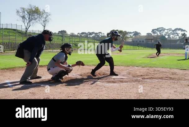 Pitcher delivering pitch triggers man sliding toward home plate to ...