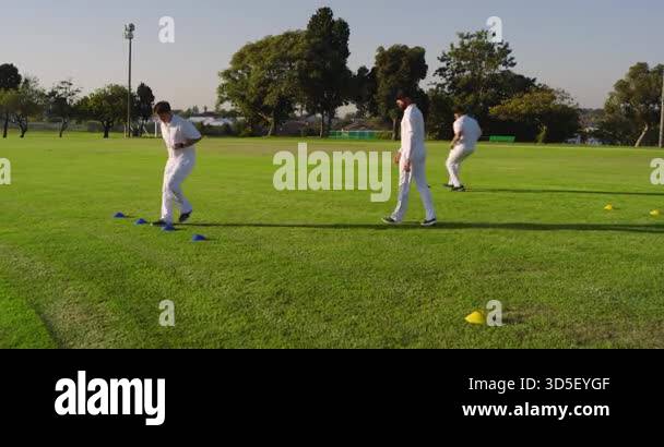 Tapping stopwatch, diverse male sports team performing agility drills ...
