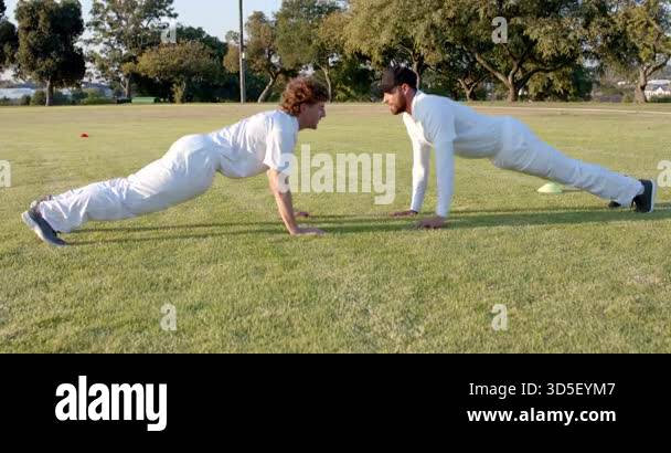 Holding plank diverse male training partners tapping alternate hands in ...