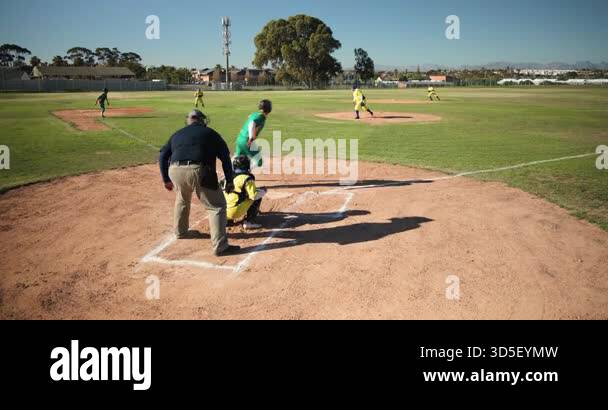 On dirt infield, pitcher is delivering pitch, batter is swinging bat ...