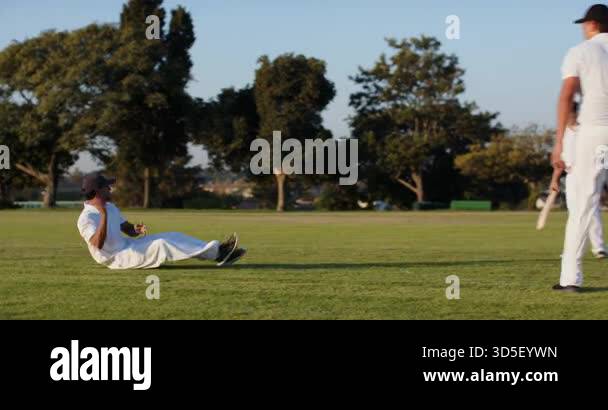 Diverse male cricket players under-arming, fielding and lobbing ball ...