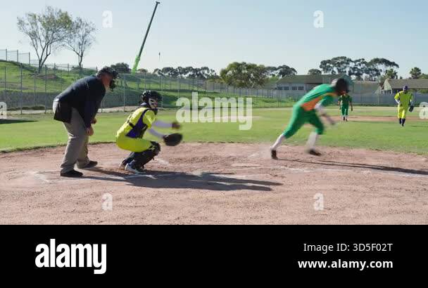 Adult male batter swinging bat at home plate after pitch, running first ...