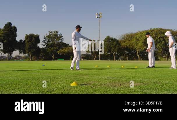Diverse male group shuffling and bounding cones on grass field after ...