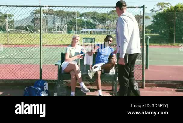 Entering from right coach greeting diverse tennis duo on bench showing ...