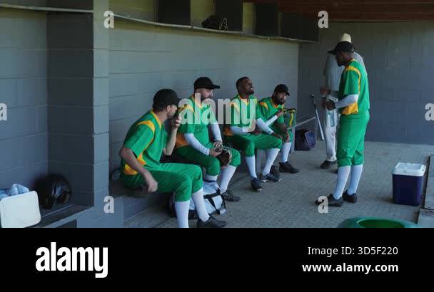 Receiving water bottle diverse baseball team preparing for game in ...