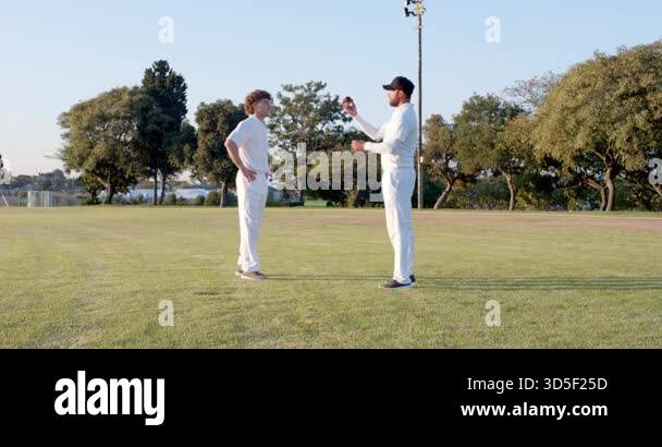 Underhand tossing coach urging trainee catching red ball lofting as ...